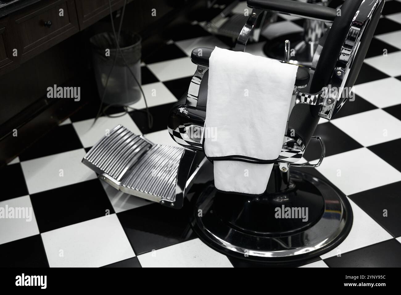 Black and white tiled barber shop with an empty barber chair waiting ...