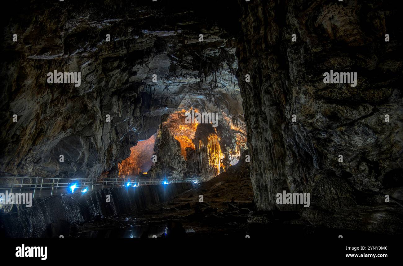 Visitors traverse a well-lit pathway within Grutas de Cacahuamilpa ...