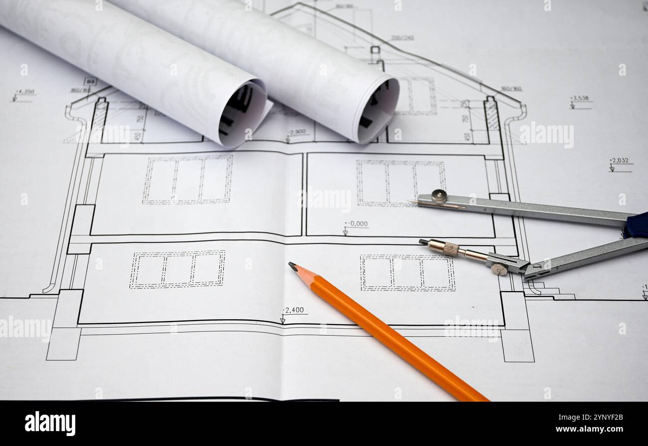Architectural Project With Compass Pencil And Rolled Blueprints Lying On Construction Plans Of