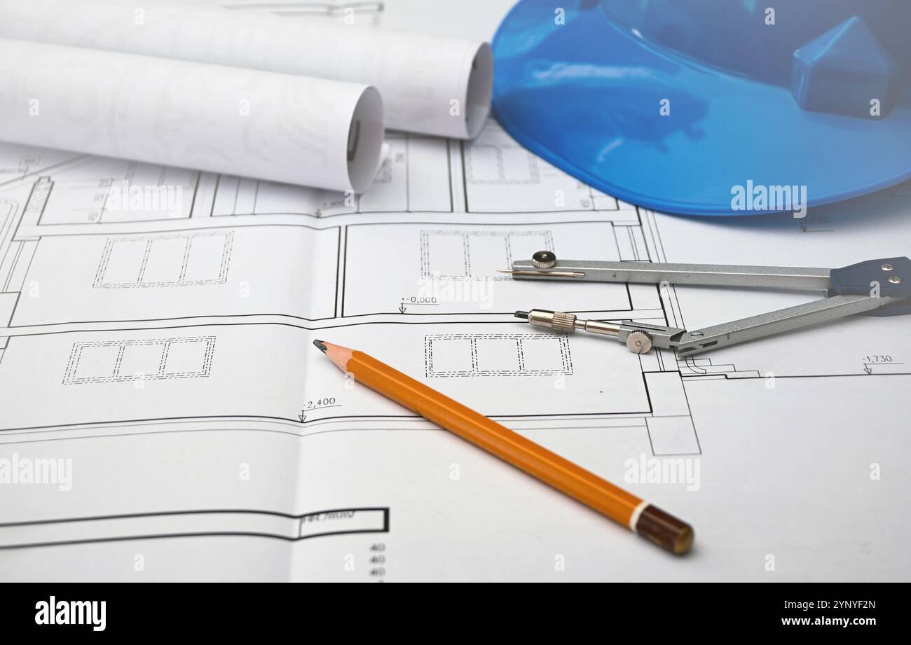 Architectural blueprints with pencil, compass and rolled blueprints and ...