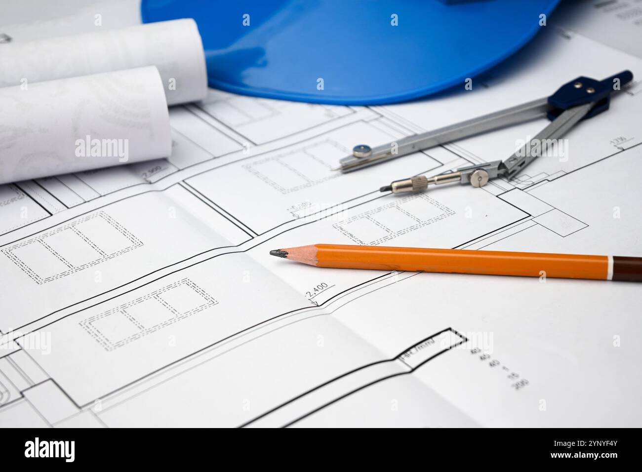 Architectural blueprints with pencil, compass and rolled blueprints and ...