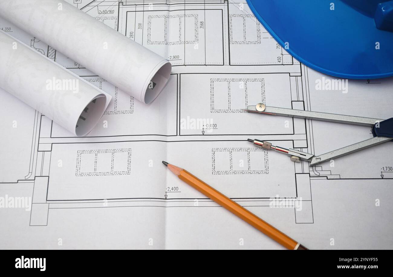 Architectural blueprints with pencil, compass and rolled blueprints and ...
