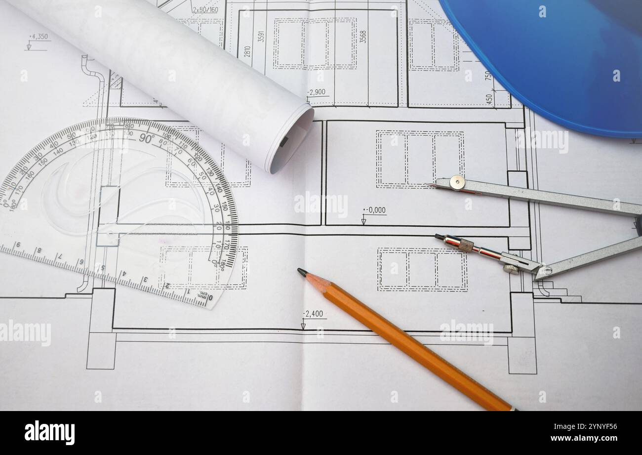 Architectural blueprints with pencil, compass and rolled blueprints and ...