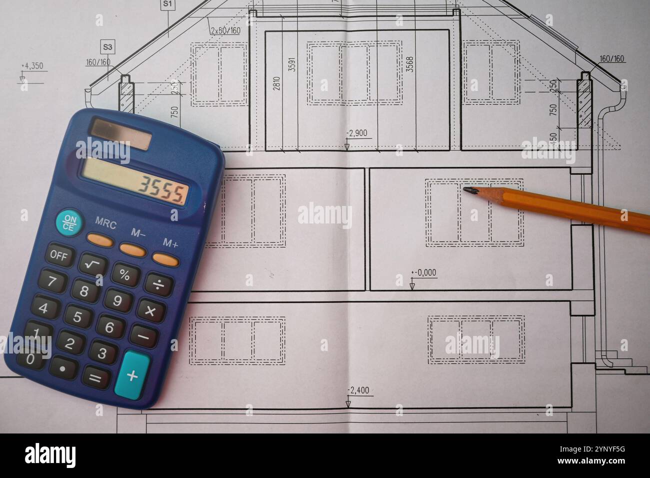 Architect calculating building costs using calculator and pencil on ...