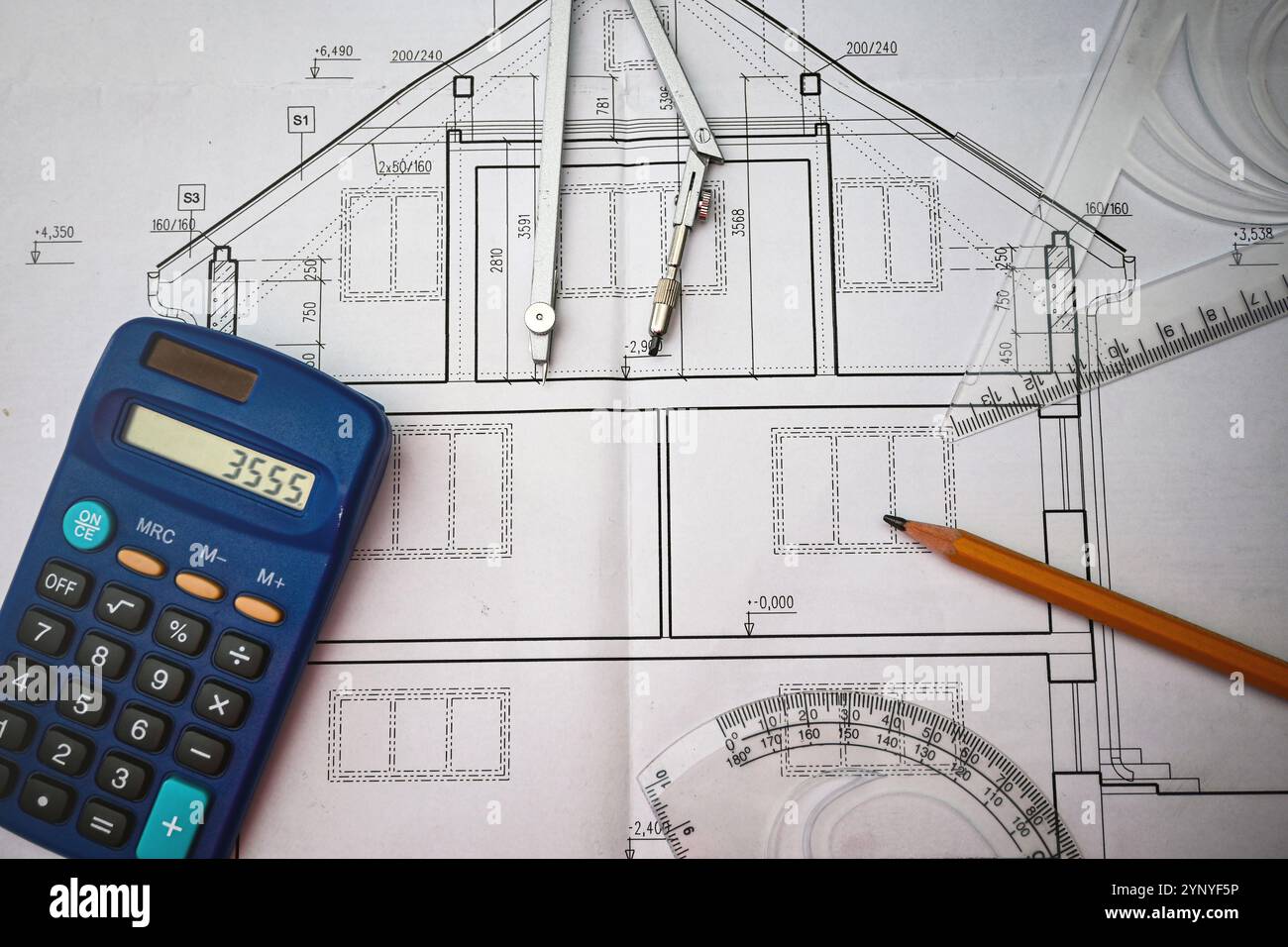 Workplace of architect designing blueprint of building using calculator, compass, protractor ...