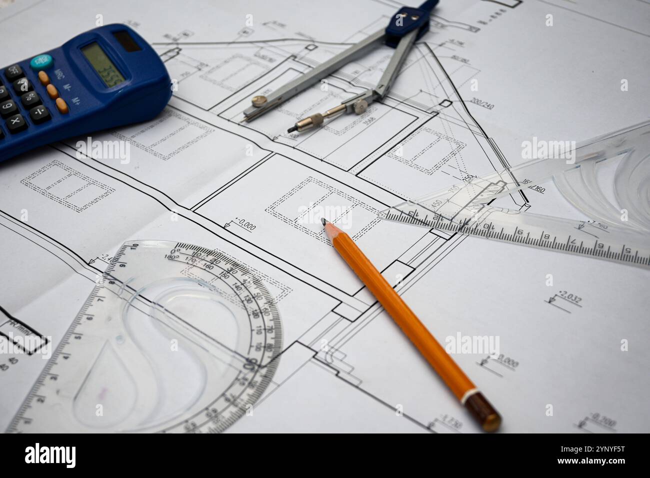 Workplace of architect designing blueprint of building using calculator, compass, protractor ...