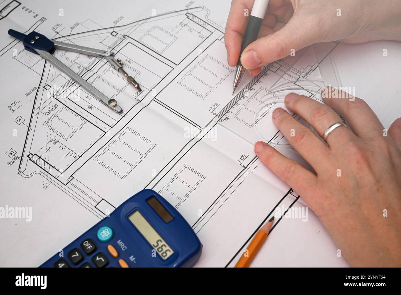 Architect drawing architectural project using compass, ruler, calculator and pencil Stock Photo ...