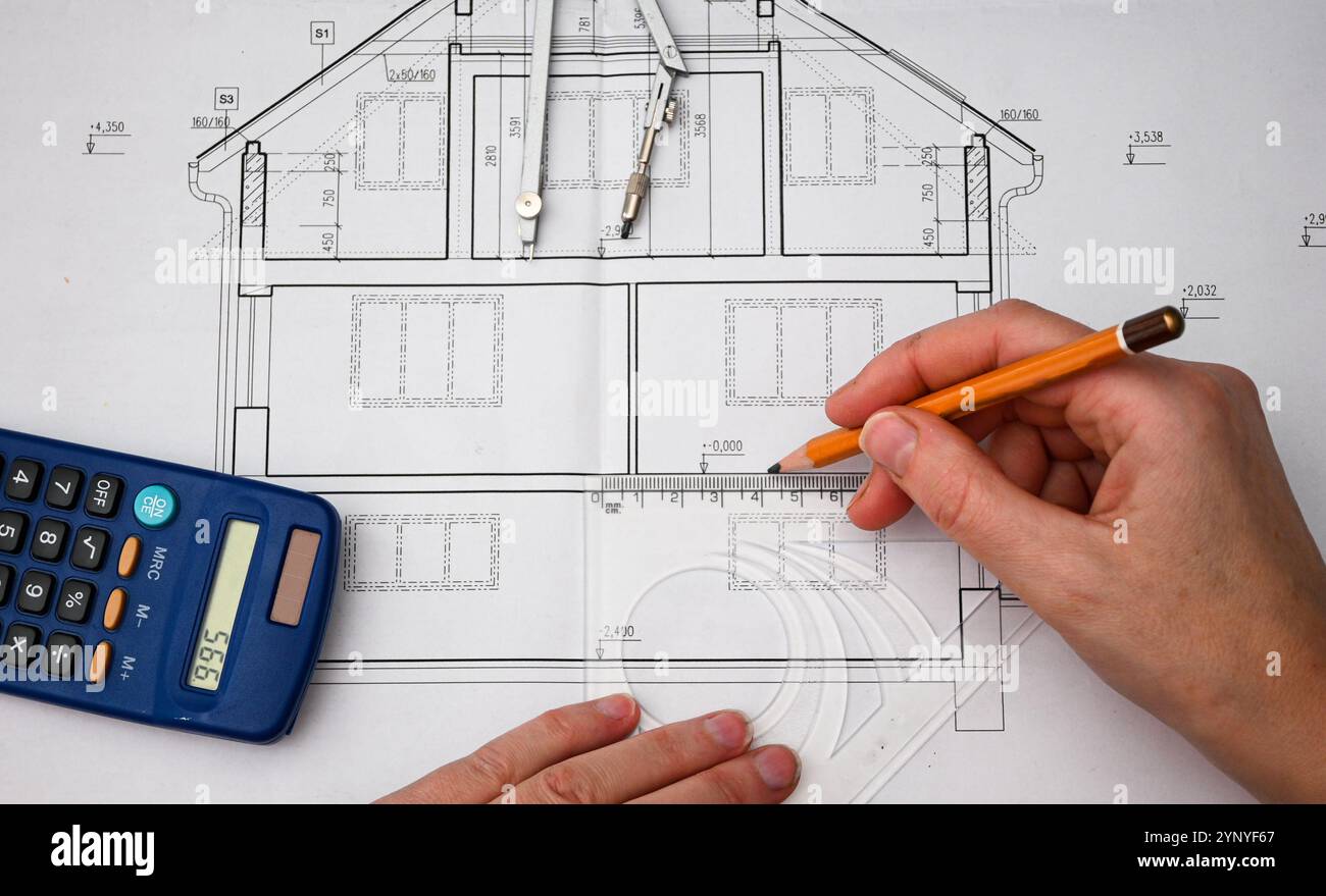 Architect drawing architectural project using compass, ruler, calculator and pencil Stock Photo ...