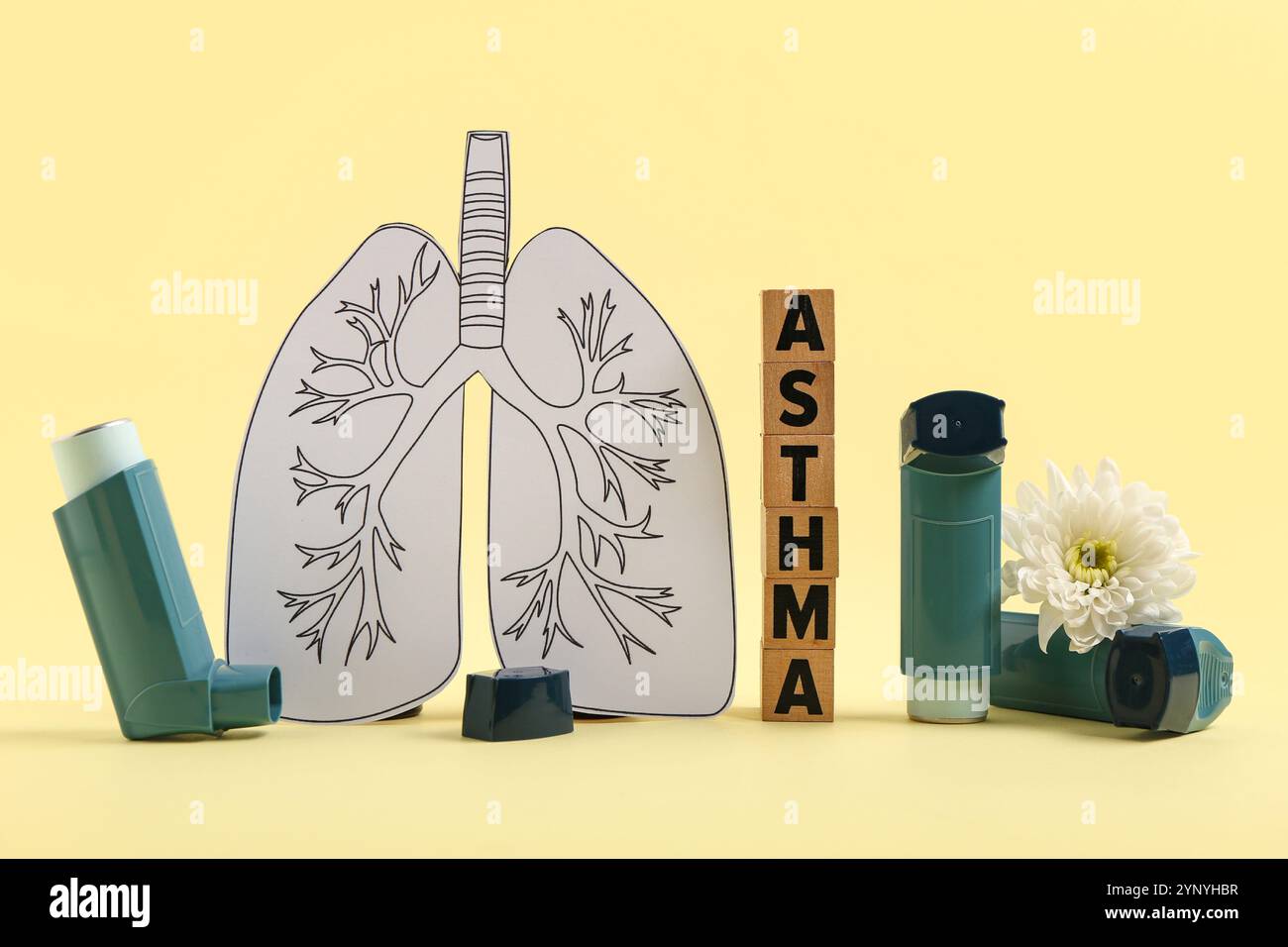 Modern inhalers with word ASTHMA and paper lungs on beige background ...