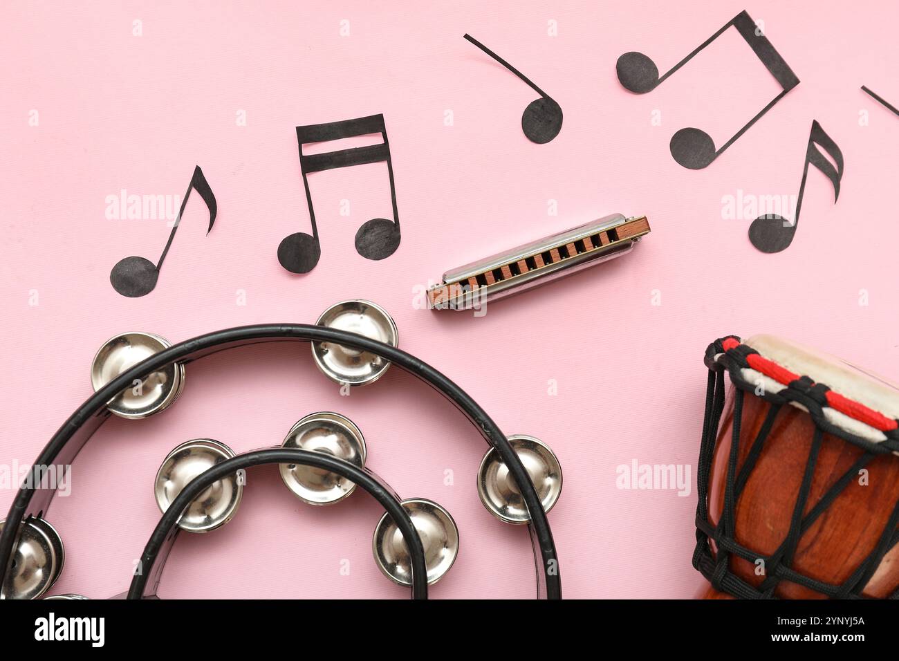 Composition with harmonica, tambourine, drum and music notes and pink ...