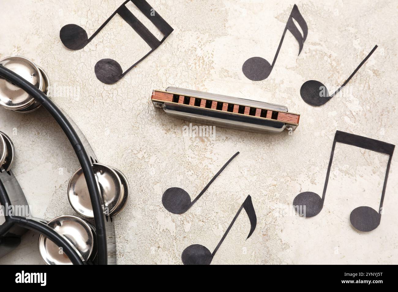 Composition with harmonica, tambourine and music notes on light ...