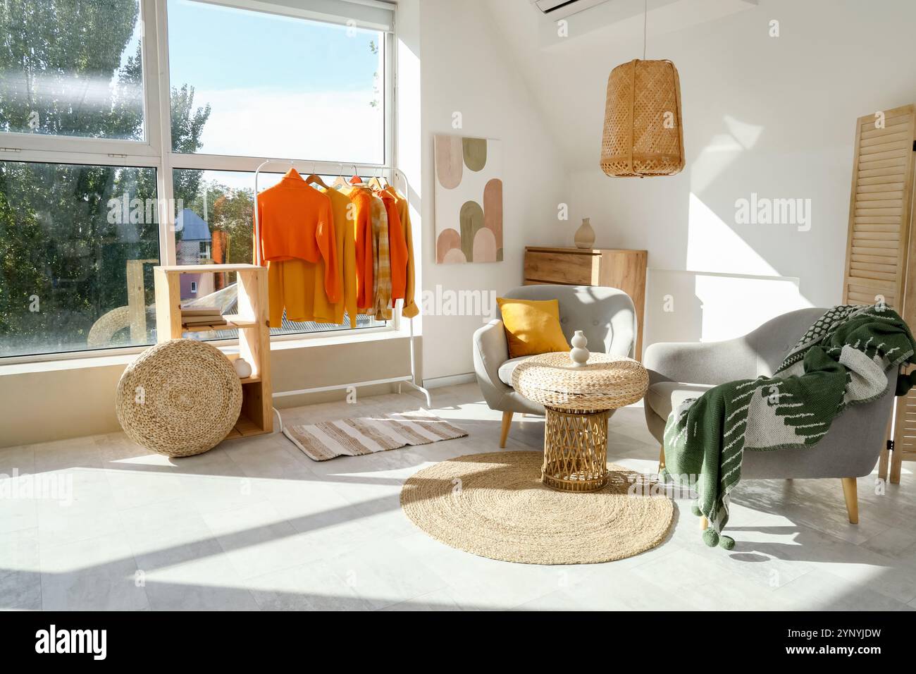 Interior of light living room with autumn clothes and armchairs Stock ...