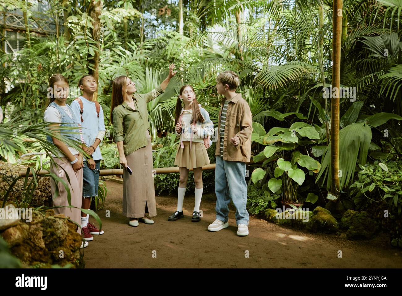 Female Tour Guide Working with Group of Teenagers in Botanical Garden ...