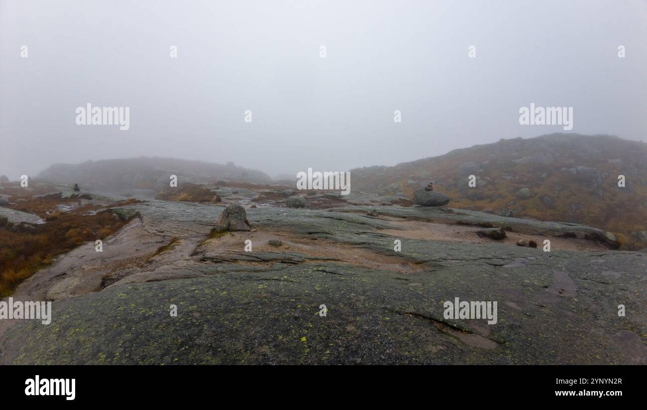 Foggy mountain landscape with rocky terrain and sparse vegetation Stock ...
