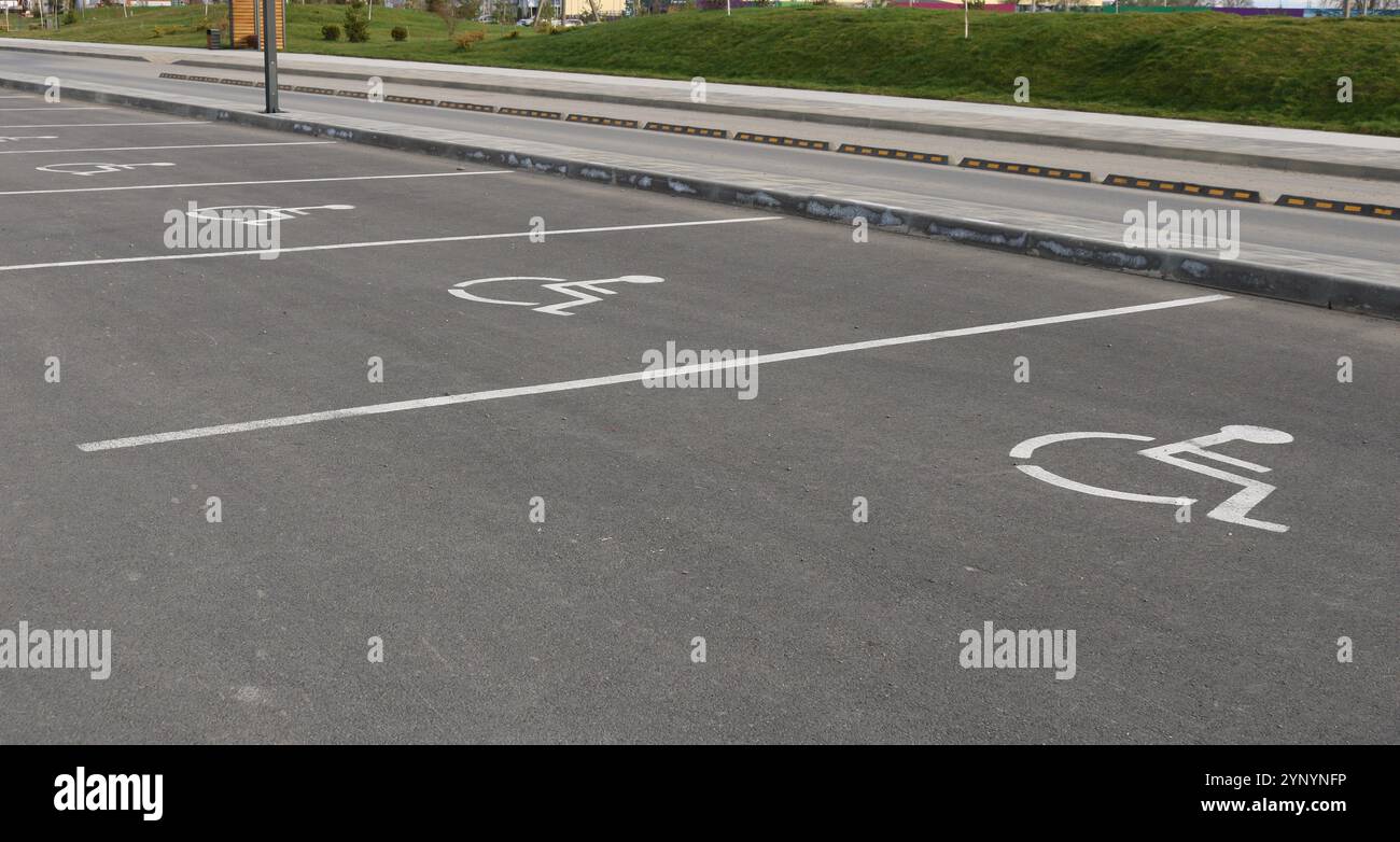 asphalt parking with several reserved spaces for people with ...