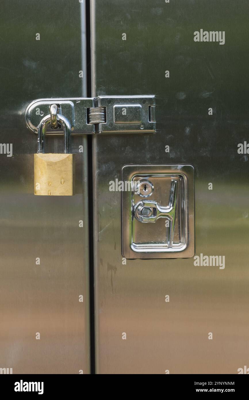 Close-up of stainless steel door on a utility cabinet locked with a ...