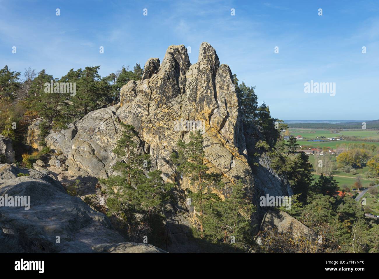 Rocky landscape with surrounding forest and a village in the background ...