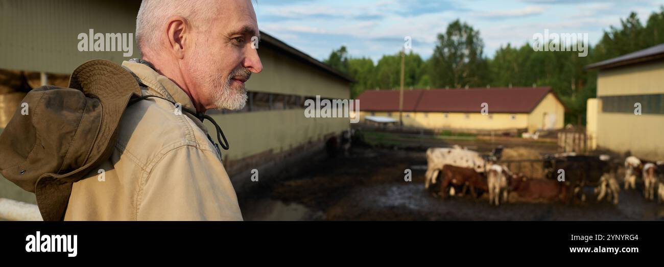 Banner of bearded mature owner of modern livestock farm standing by ...