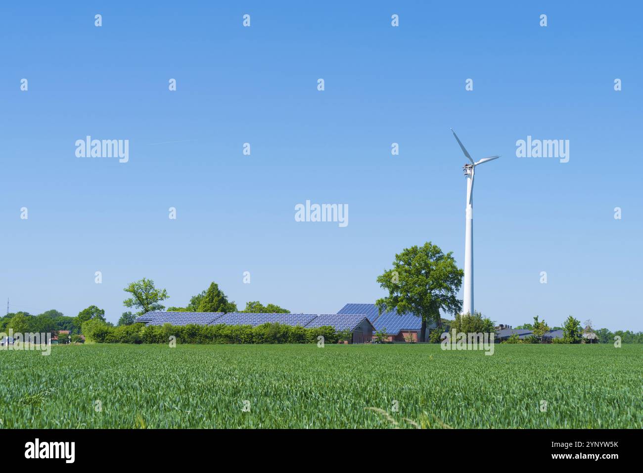 Modern farmhouse with solar panels and a wind turbine Stock Photo - Alamy