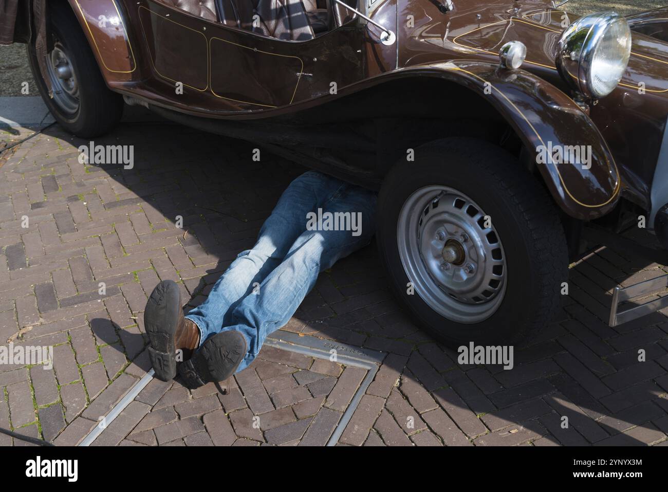 Mechanic lying under a car Stock Photo - Alamy