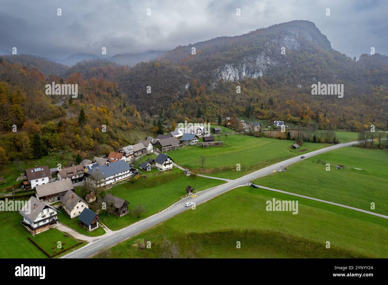 Drone scene White car driving on country road near small village of ...