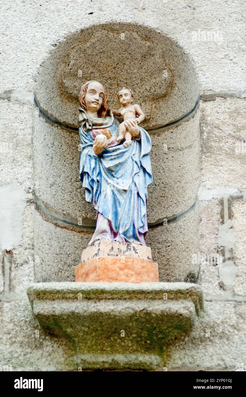 A religious statue set in a recessed wall space in Quimper, France ...