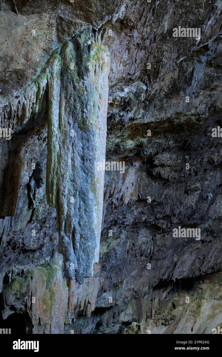 The image showcases a rugged cave interior with stalactites and ...
