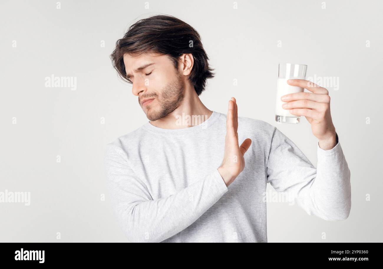 Food allergies and lactose intolerance. Man refuses of glass of milk ...