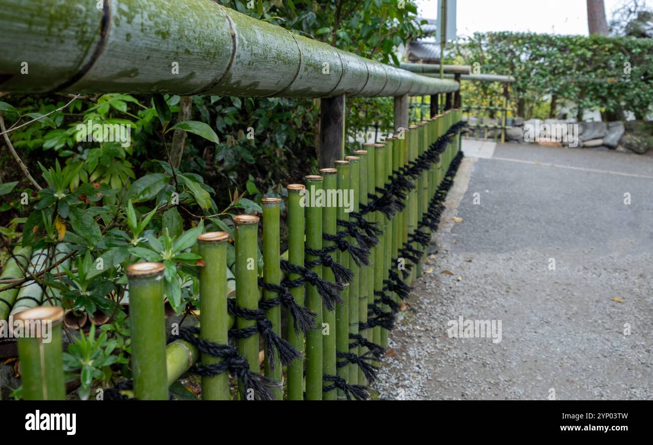 Bamboo fence vertical rods and horizontal railing, tied together with ...