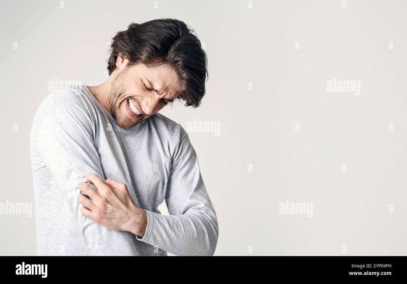 Allergic reaction. Man scratches his hand with force and suffers from ...