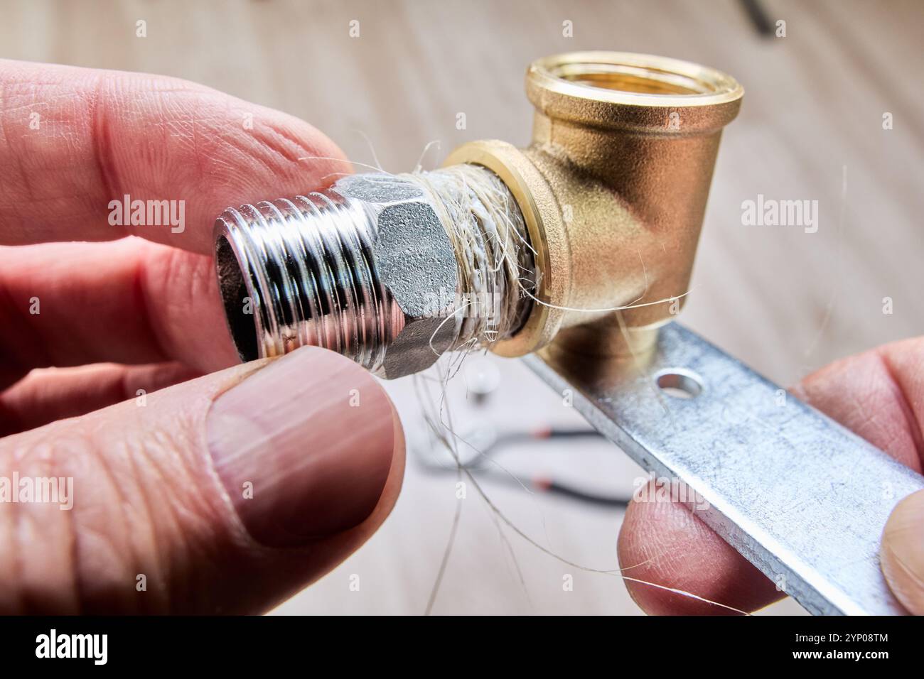 Plumbing hemp with sealing paste seals threaded connection on hexagonal ...