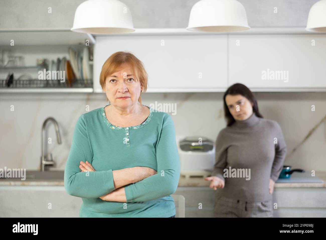 Frustrated elderly mother having tense conversation with her daughter ...