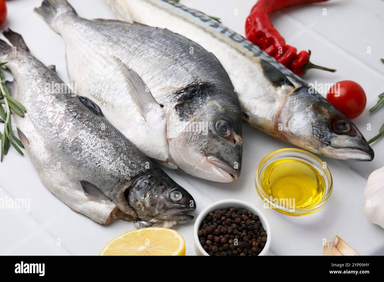 Sea food. Different types of raw fish and products on white tiled table ...