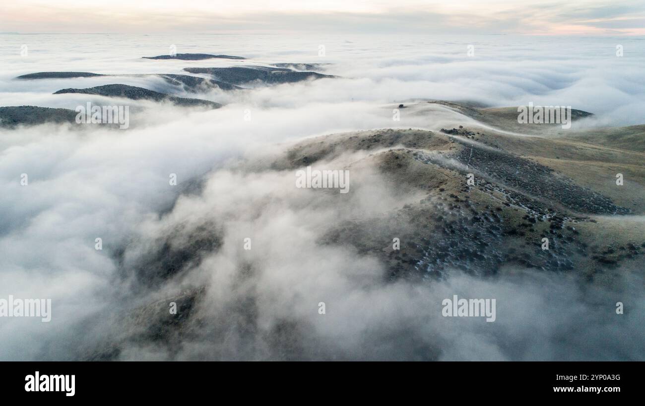 The sky is covered in a thick layer of fog, creating a moody and ...