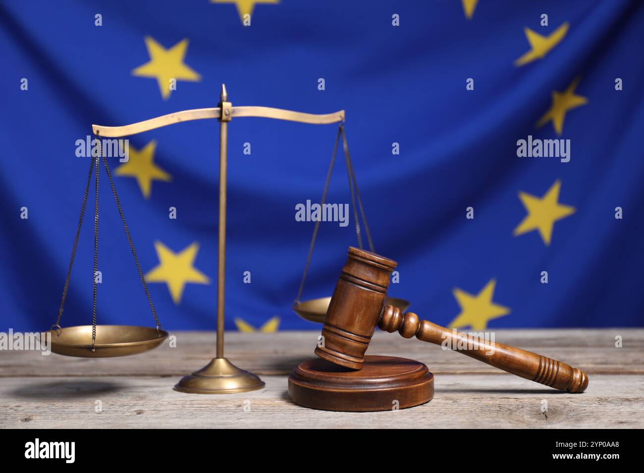 Scales of justice and judge's gavel on wooden table against European ...