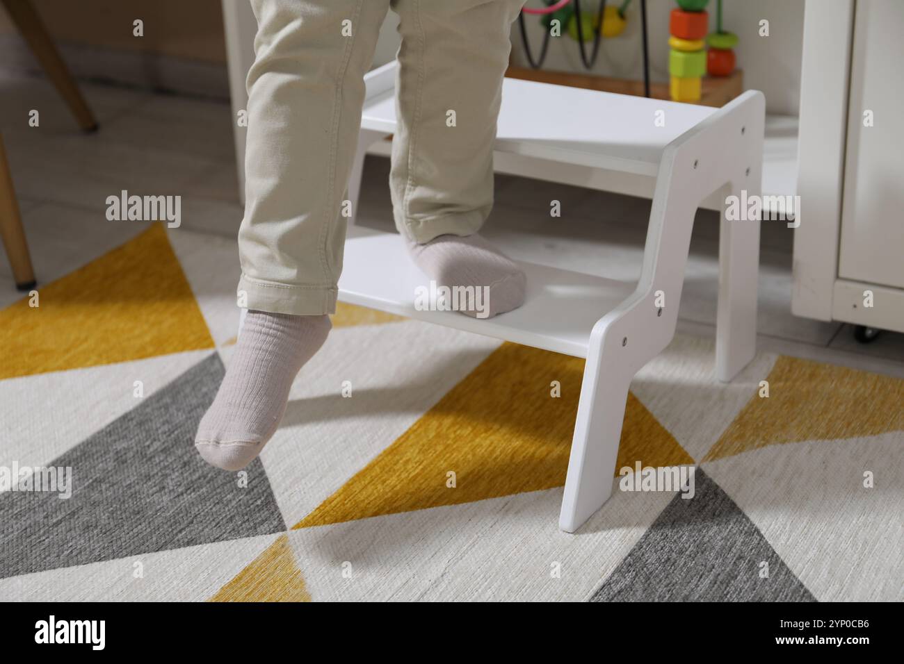 Little boy standing on step stool at home, closeup Stock Photo - Alamy