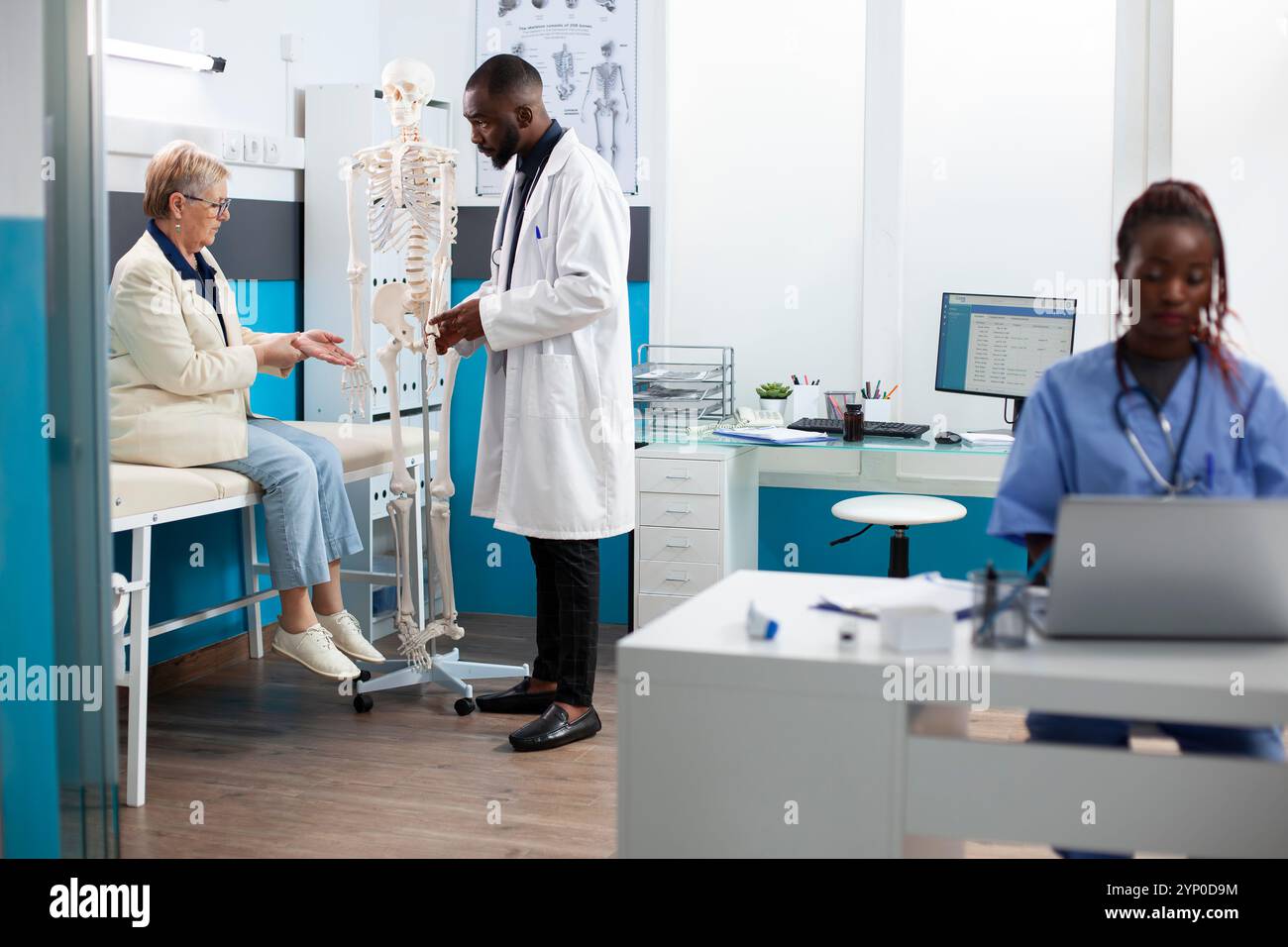 Elderly female patient sits on hospital bed listening attentively to ...