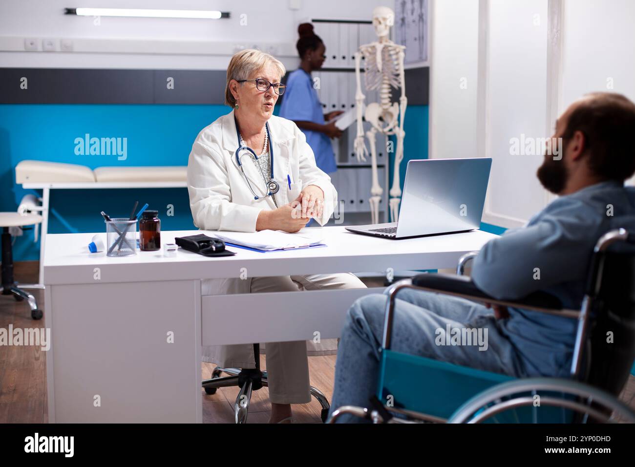 In hospital room, senior doctor reviews treatment options with ...