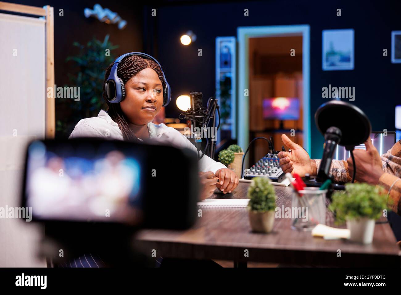 Female presenter filming a live chat show at home with quality camera ...