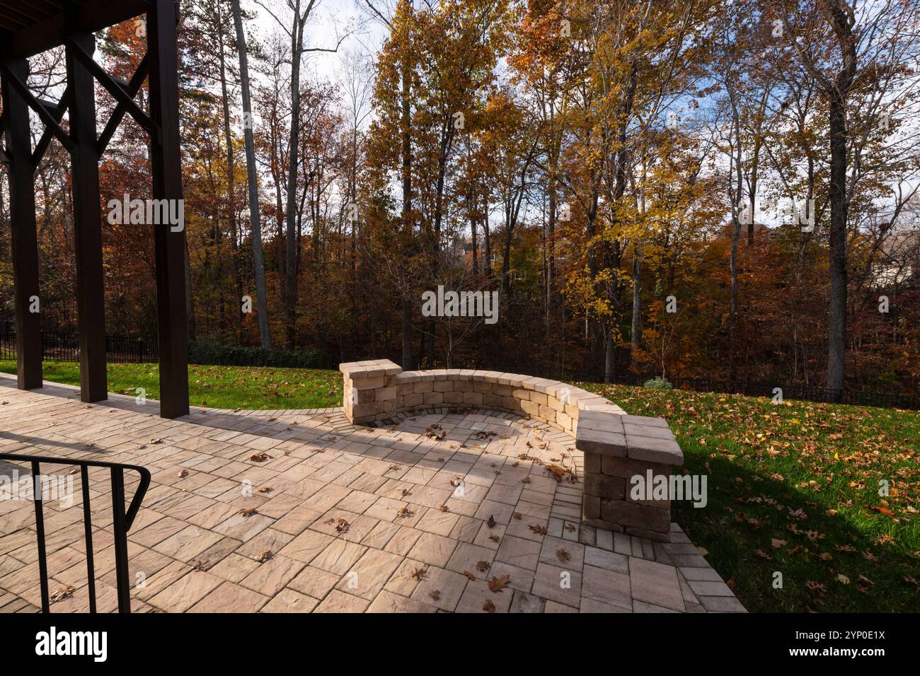 A picturesque autumn backyard with a curved stone patio and steps ...