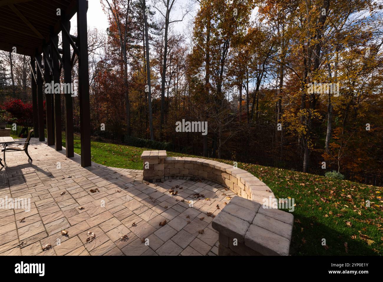 A picturesque autumn backyard with a curved stone patio and steps ...