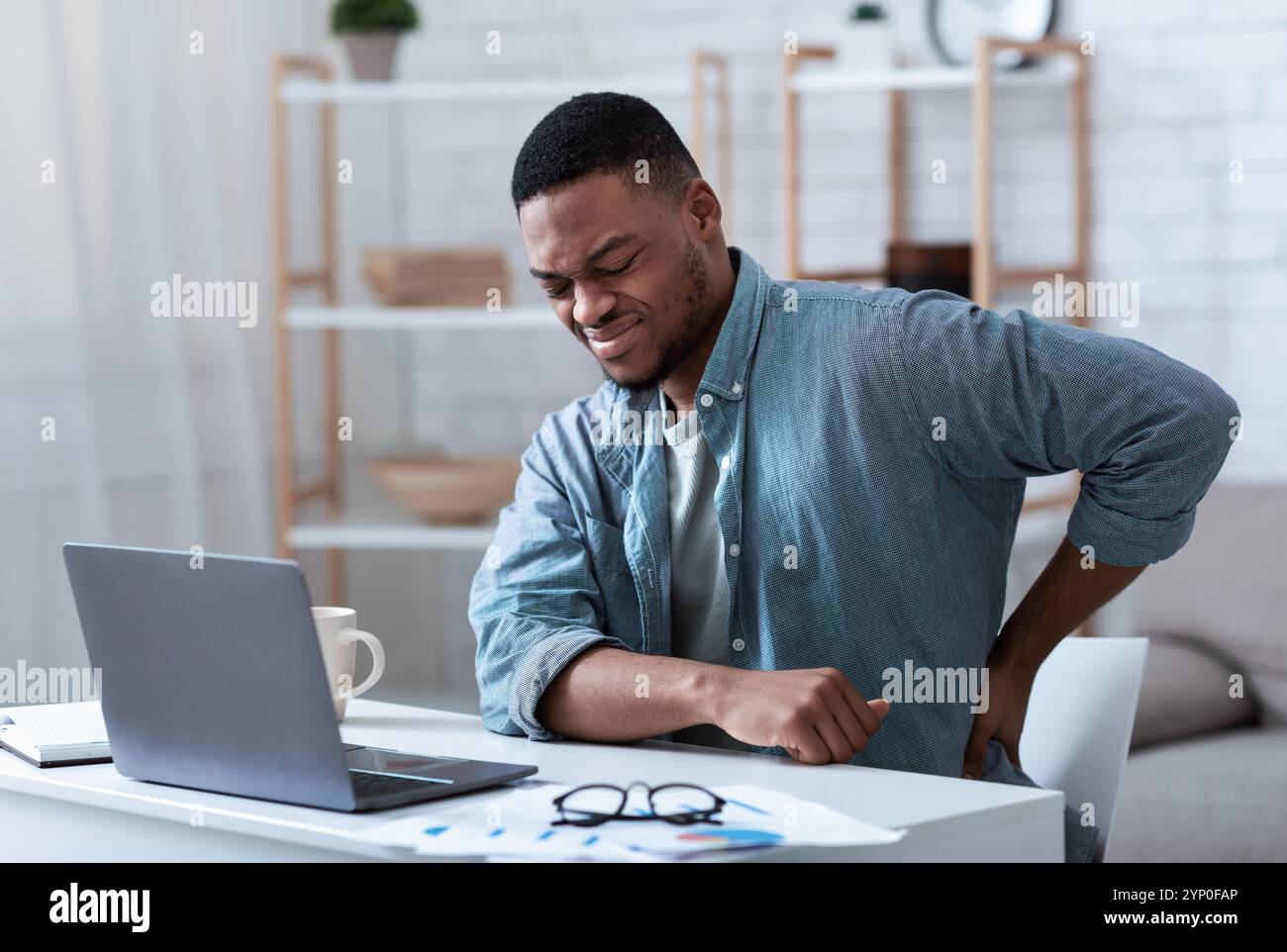 African Guy Having Backache Massaging Aching Back At Workplace Indoor ...