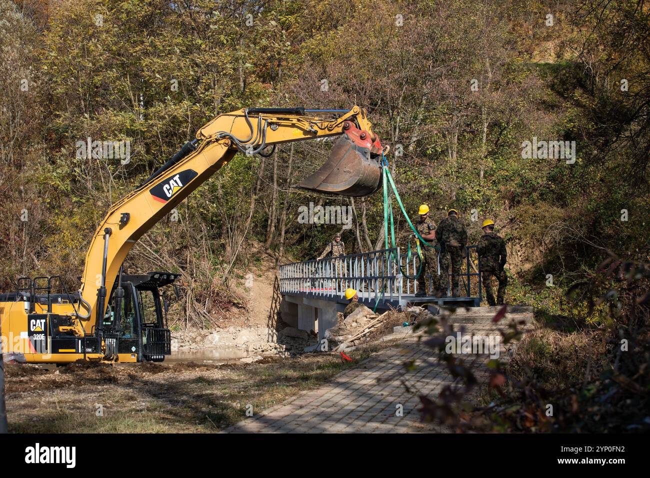 Swiss Army engineers construct a pedestrian bridge over the Ibar River ...