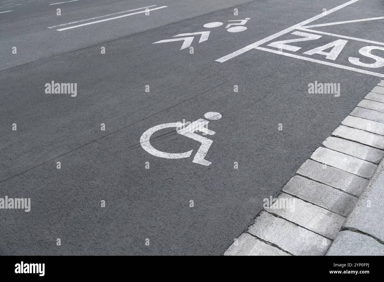 Road markings on asphalt indicate a disabled parking space, a ...