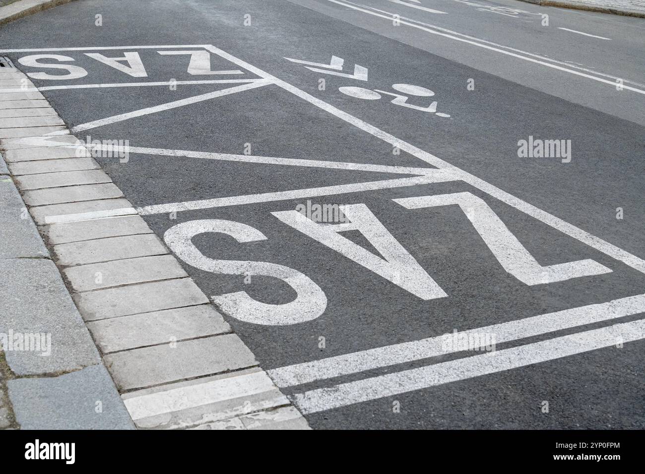 Road markings on asphalt indicate a designated bike lane, and a bus ...