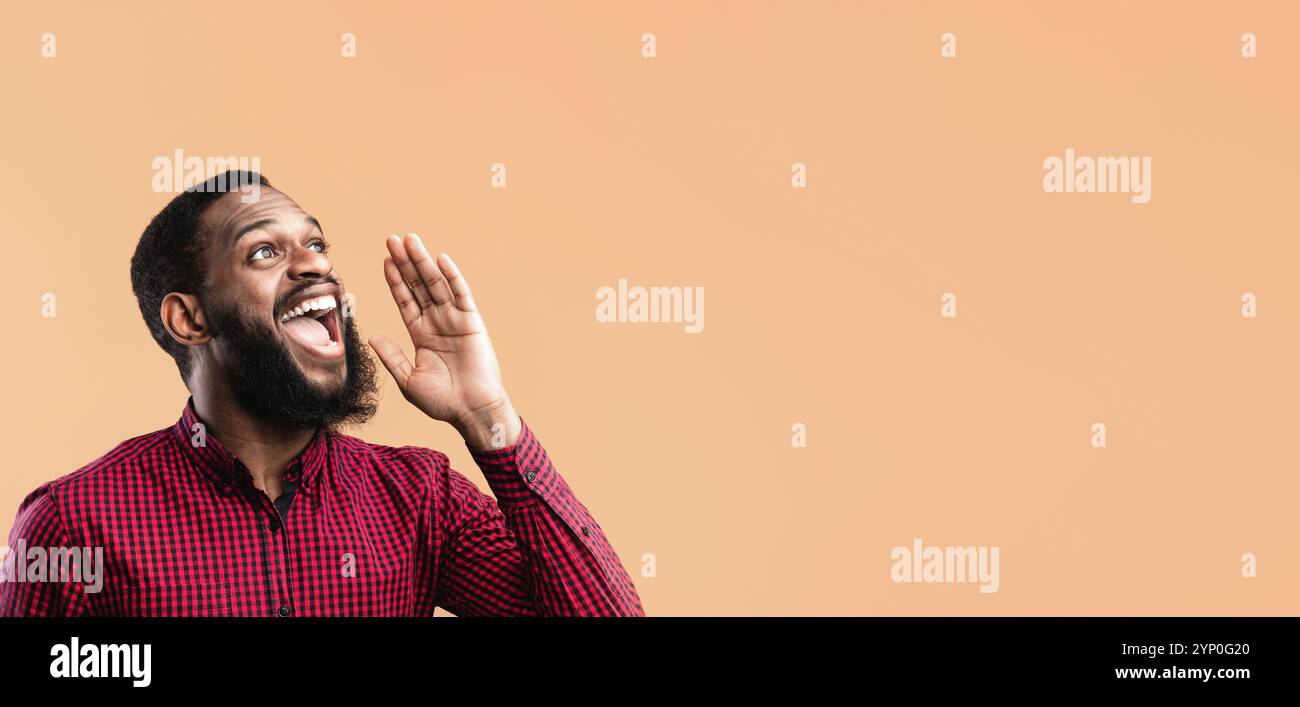 Black guy holding hand near mouth, screaming aside Stock Photo - Alamy
