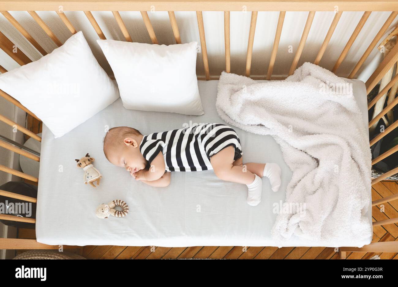 Cute infant baby napping on his side in wooden cot Stock Photo - Alamy