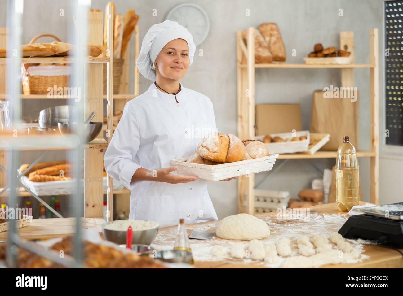 Bakery woman employee holds ready made bread of bread Stock Photo - Alamy