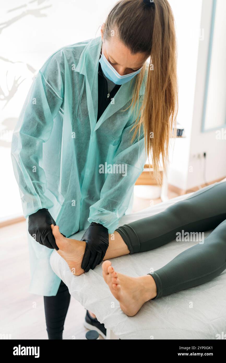Doctor examining female patient's foot in clinic room Stock Photo - Alamy