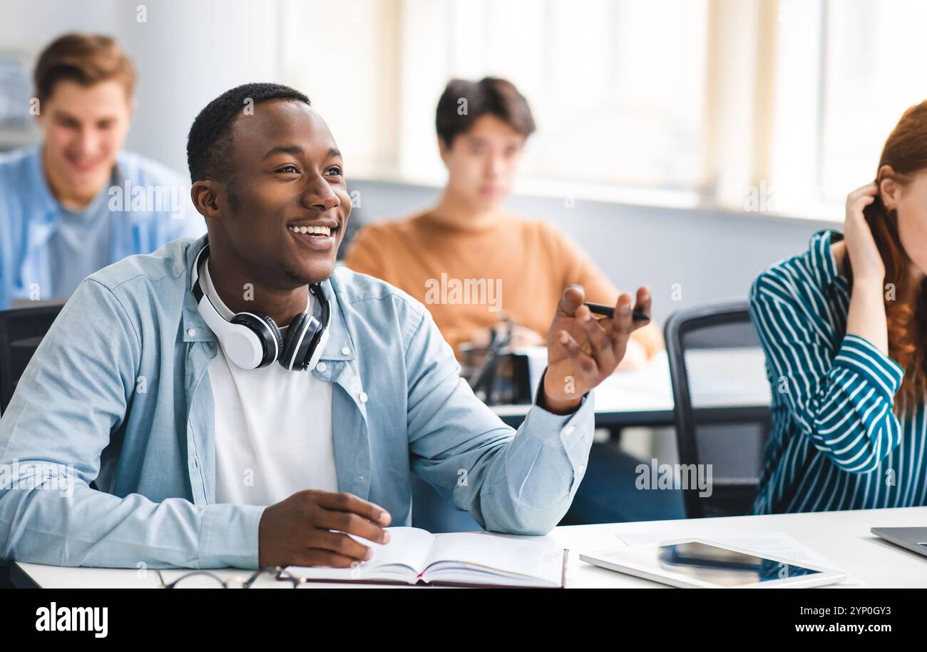 Smiling black student talking to teacher at classroom Stock Photo - Alamy